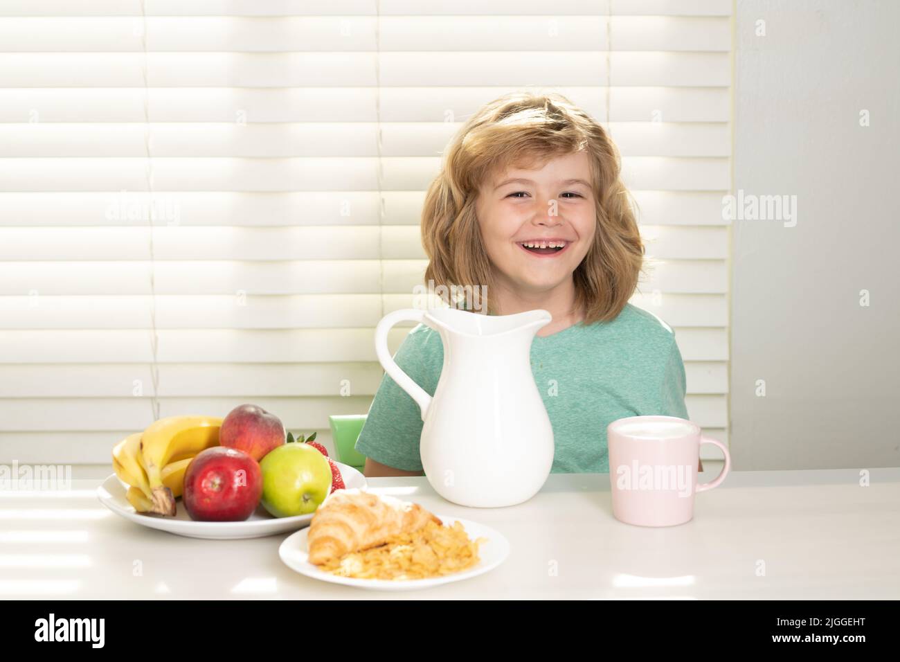 Portrait of preteen child eat fresh healthy food in kitchen at home ...