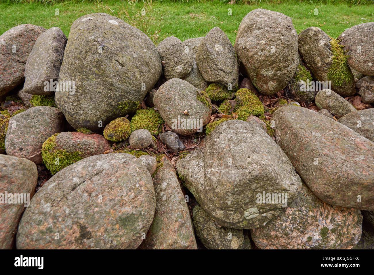 Closeup of a stone wall made of boulders and rocks outside. Background ...