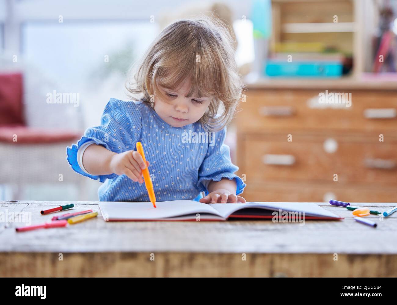 She can keep herself busy all day. a little girl drawing at home Stock ...