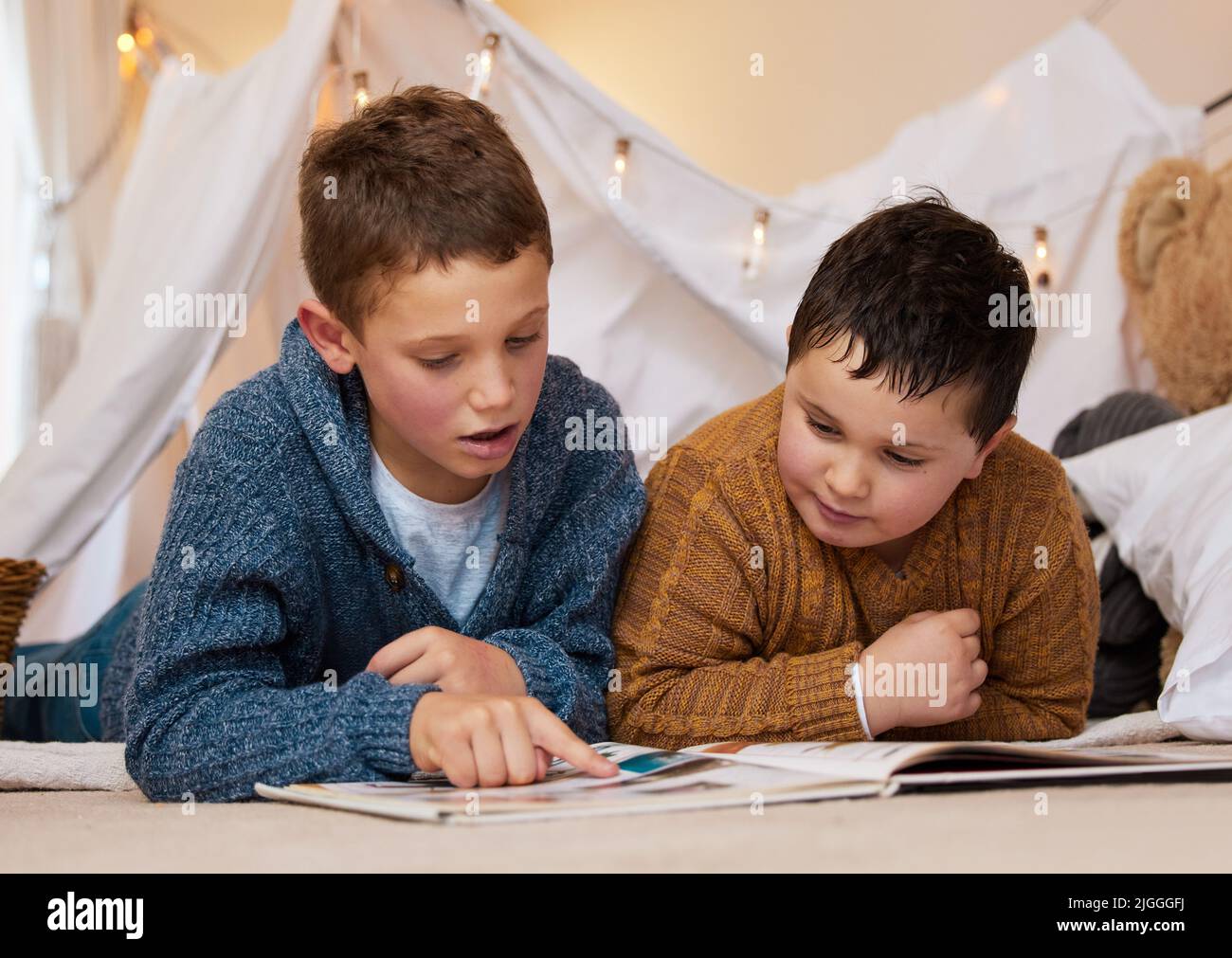 Hooked to an interesting new book. two brothers reading a book together ...