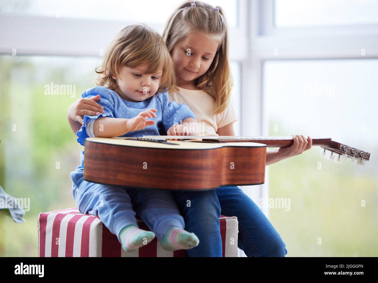 She loves teaching her sister something new. two little sisters playing ...