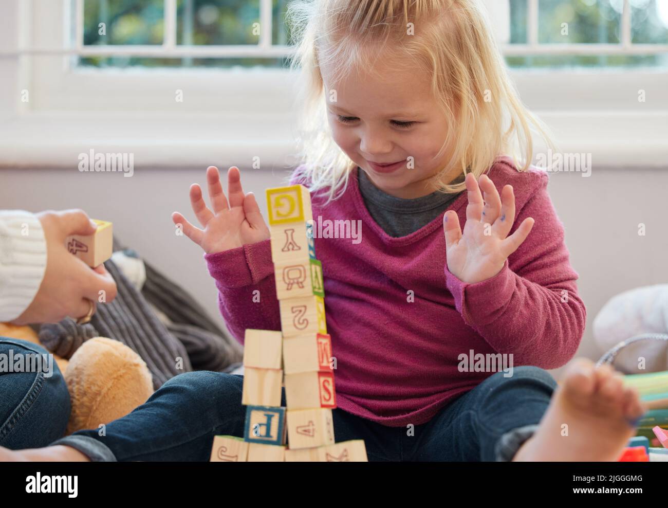 I did it. a little girl stacking blocks with her mother at home Stock ...