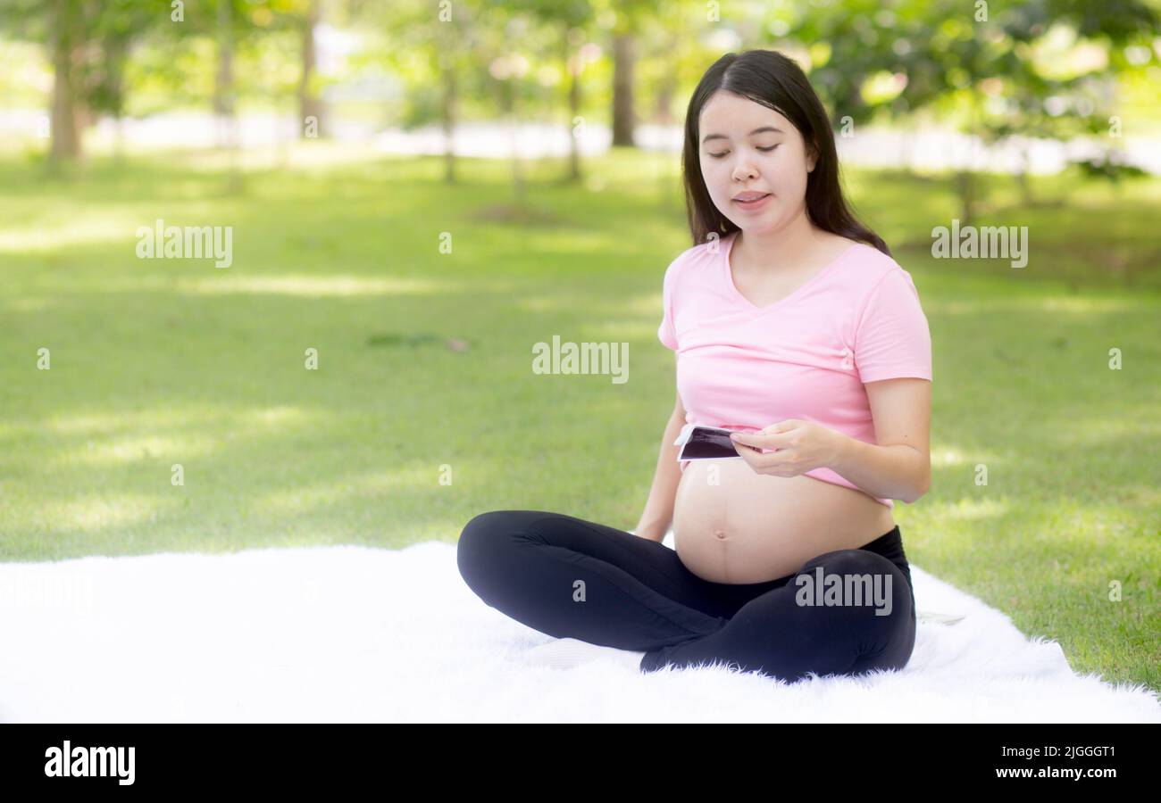 Happiness young asian woman pregnant sitting touch belly and looking ...