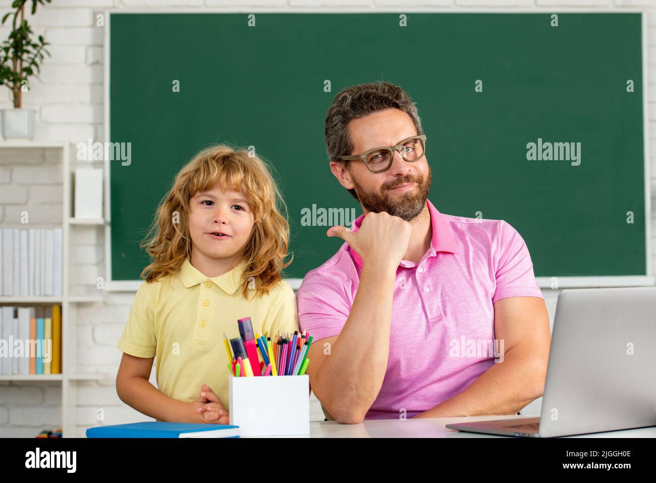 Father teacher helping a son boy in school lessons. Education and ...