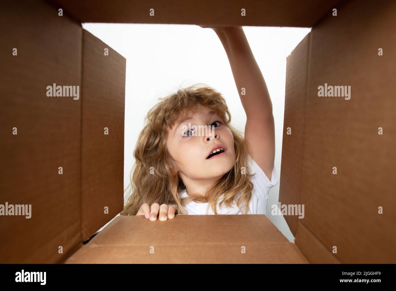 Cheerful cute child opening a present. Cardboard boxes, parcels ...