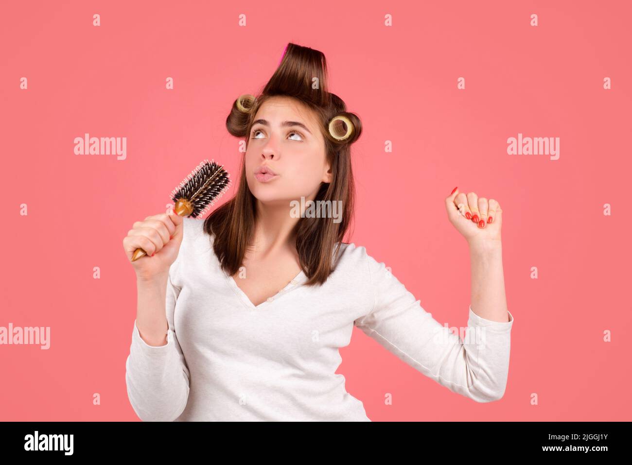Funny woman singing with comb. Female brushing healthy hair with comb ...