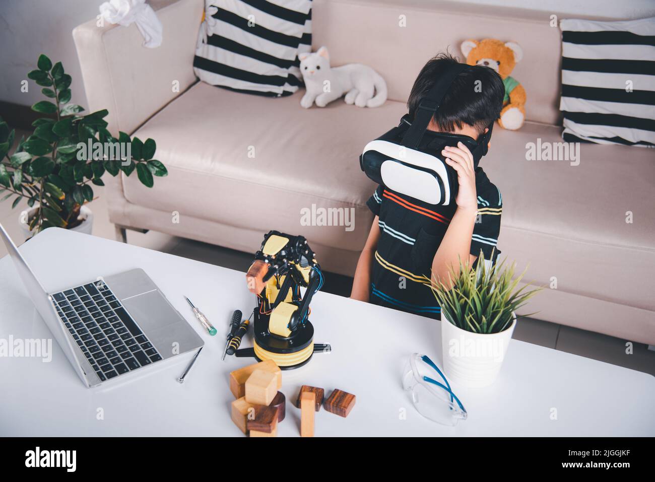 Virtual Reality Simulator. Asian kid boy using VR glasses on robotic ...