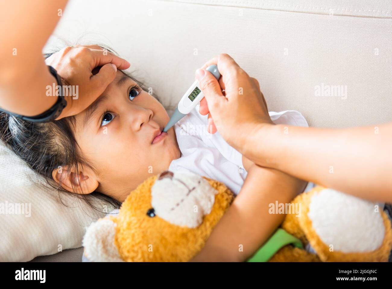 Sick kid. Mother checking temperature of her sick daughter with thermometer in mouth, child ...