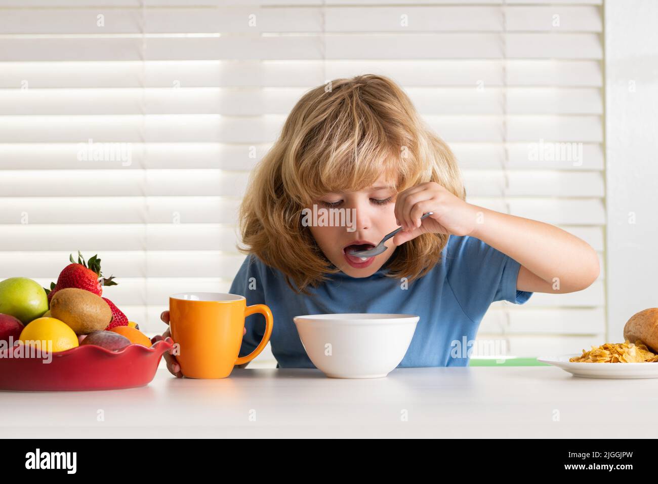 Hunger, appetite concept. Funny blonde little boy having breakfast ...
