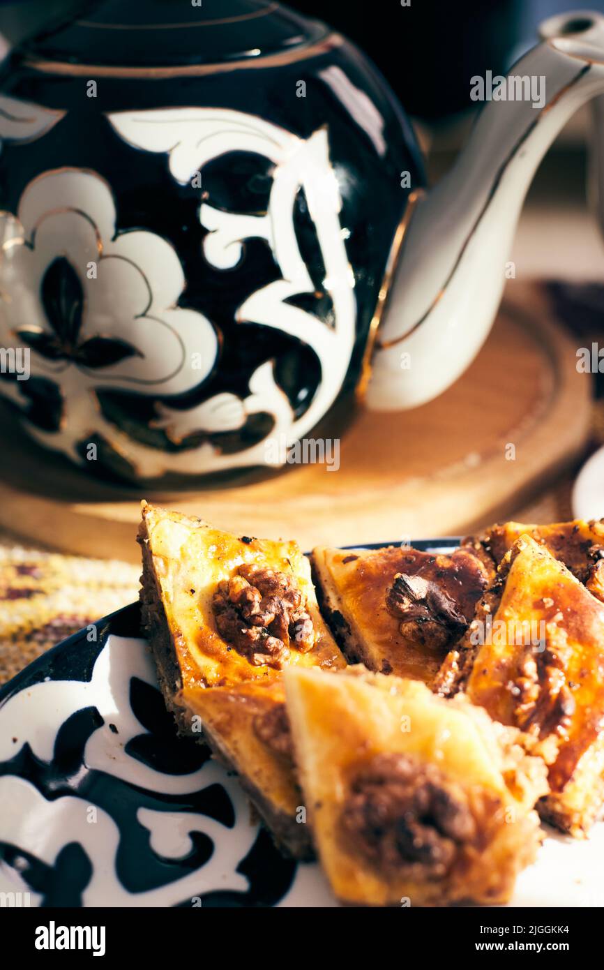 A teapot with tea and a plate with national sweets - baklava. Vertical ...