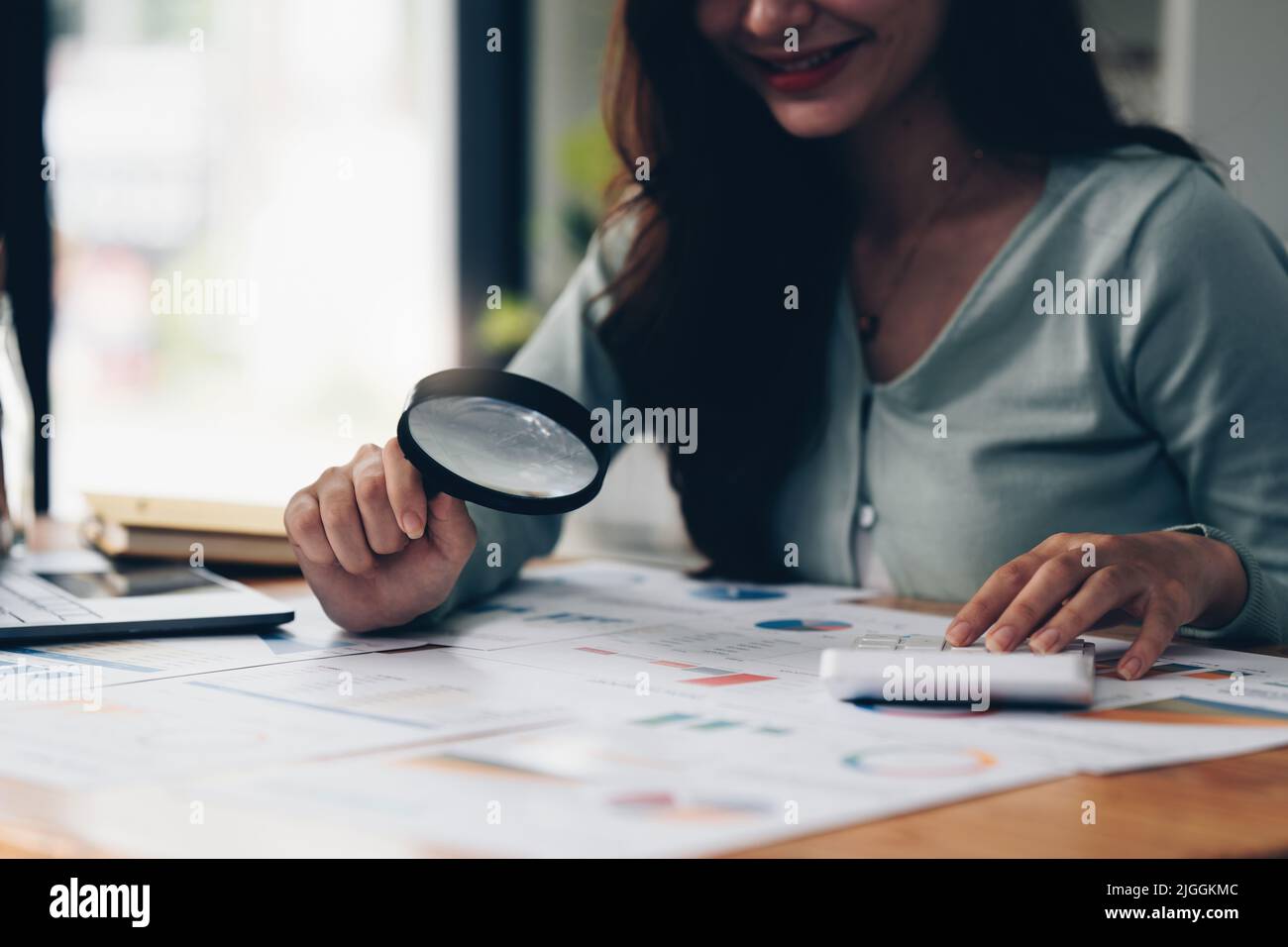 Portrait of Business woman using magnify to audit the company's ...