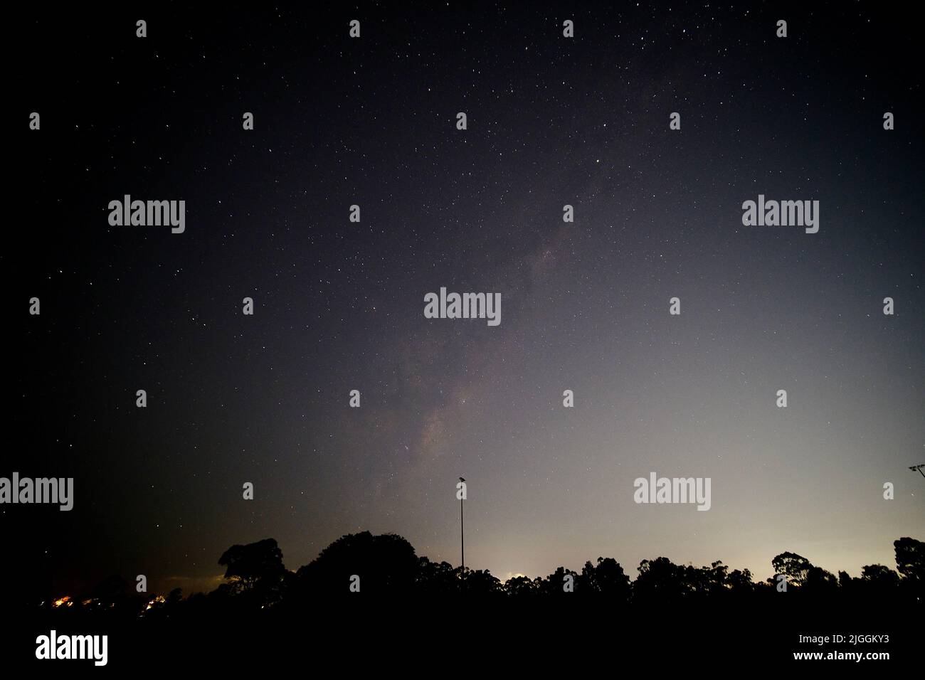A breathtaking view of a glowing, starry sky at night with silhouettes ...