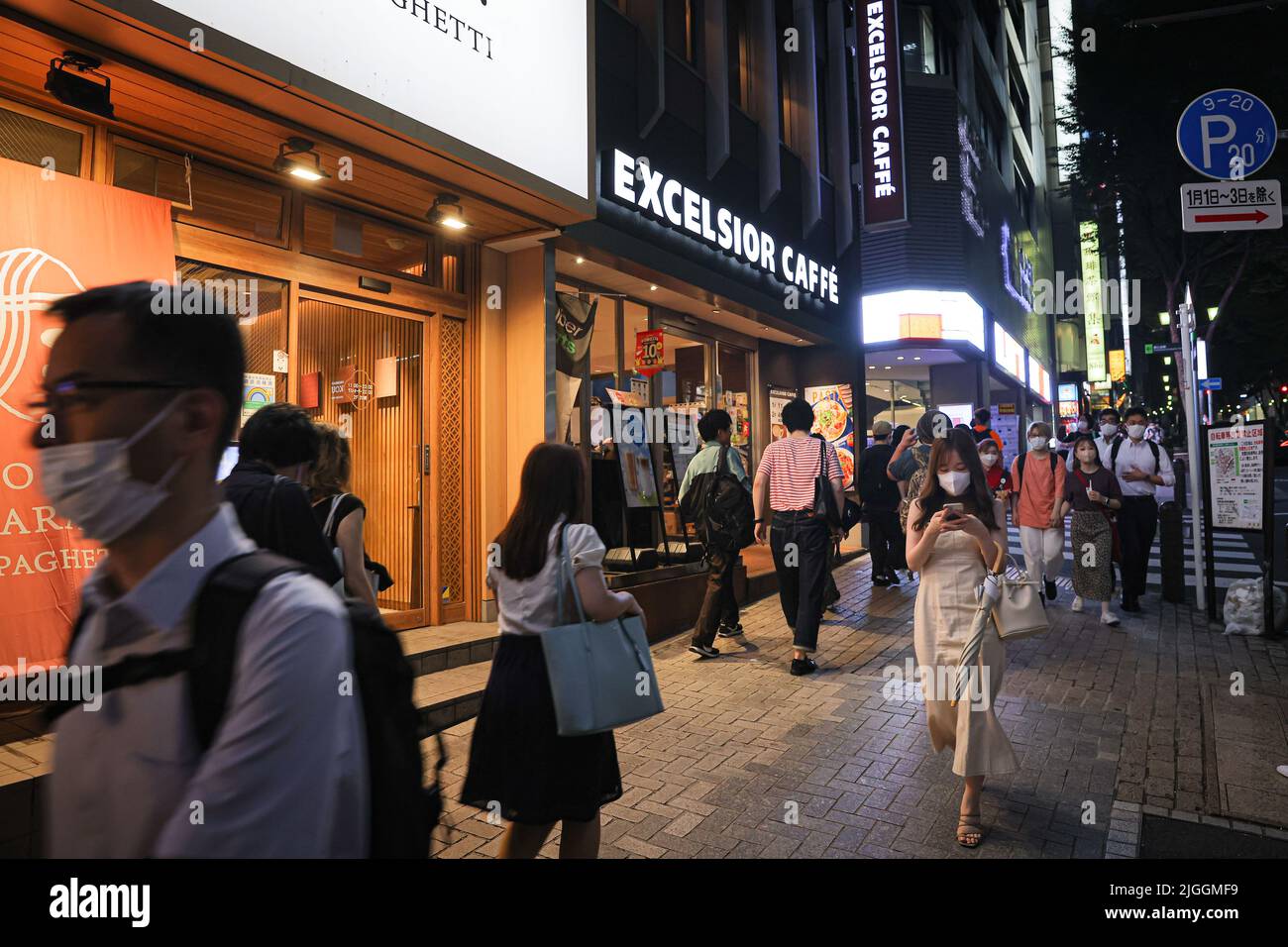Tokyo, Japan. 30th June, 2022. Pedestrians wearing face masks walk down ...