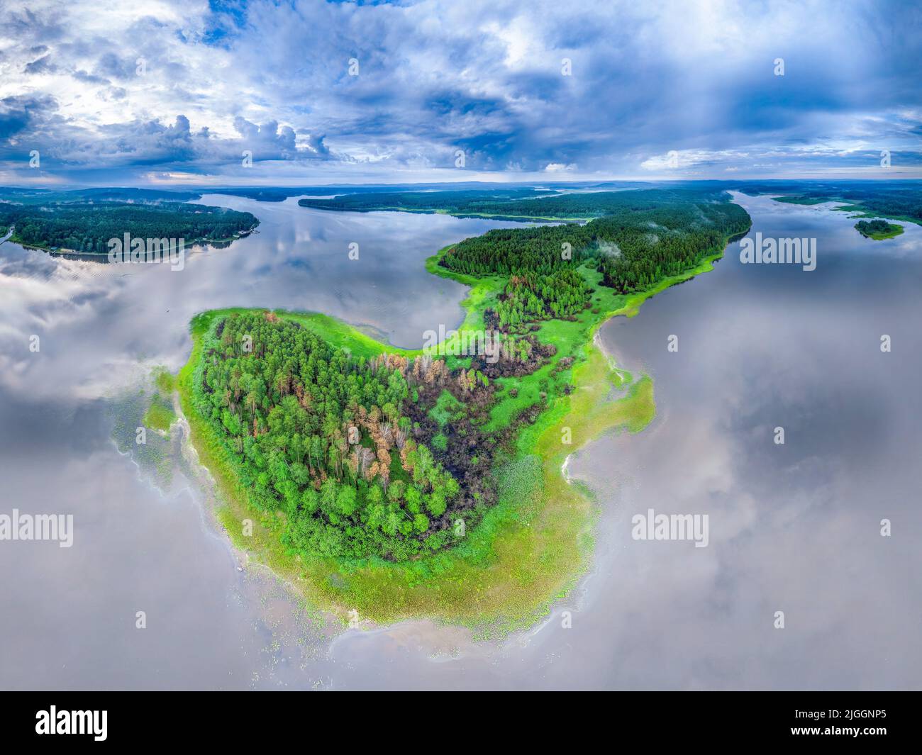 Big lake with green shores in bright sun light, aerial landscape ...