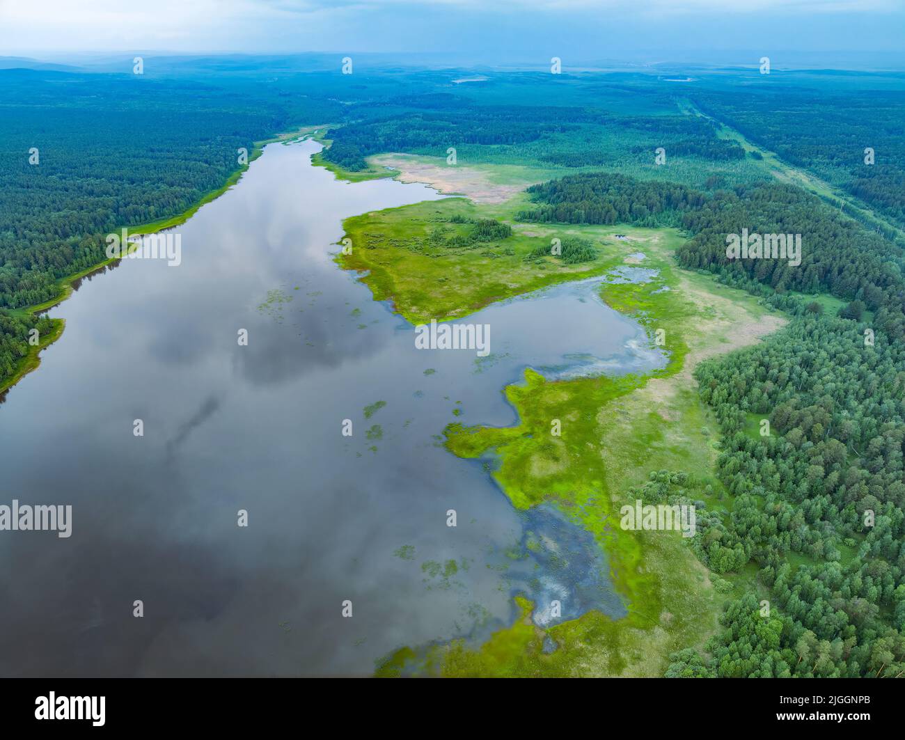 Big lake with green shores in bright sun light, aerial landscape ...