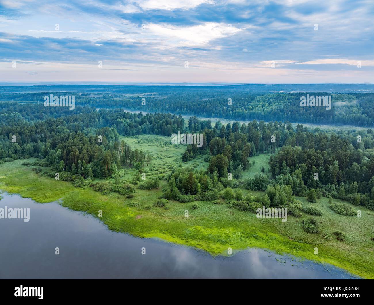 Big lake with green shores in bright sun light, aerial landscape ...