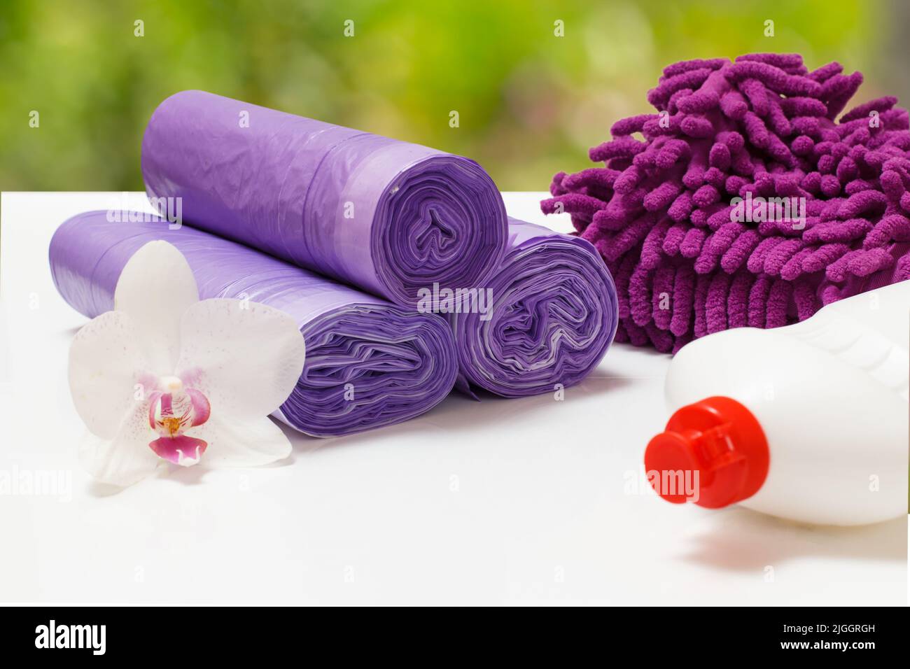 Plastic bottle of washing liquid, garbage bags, a rag and a white ...