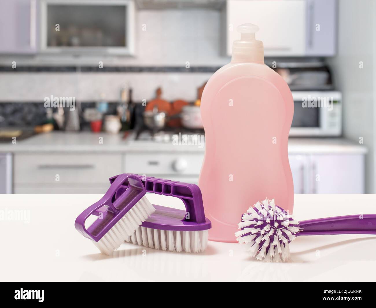 Bottle of dishwashing liquid and brushes in the kitchen. Washing and ...