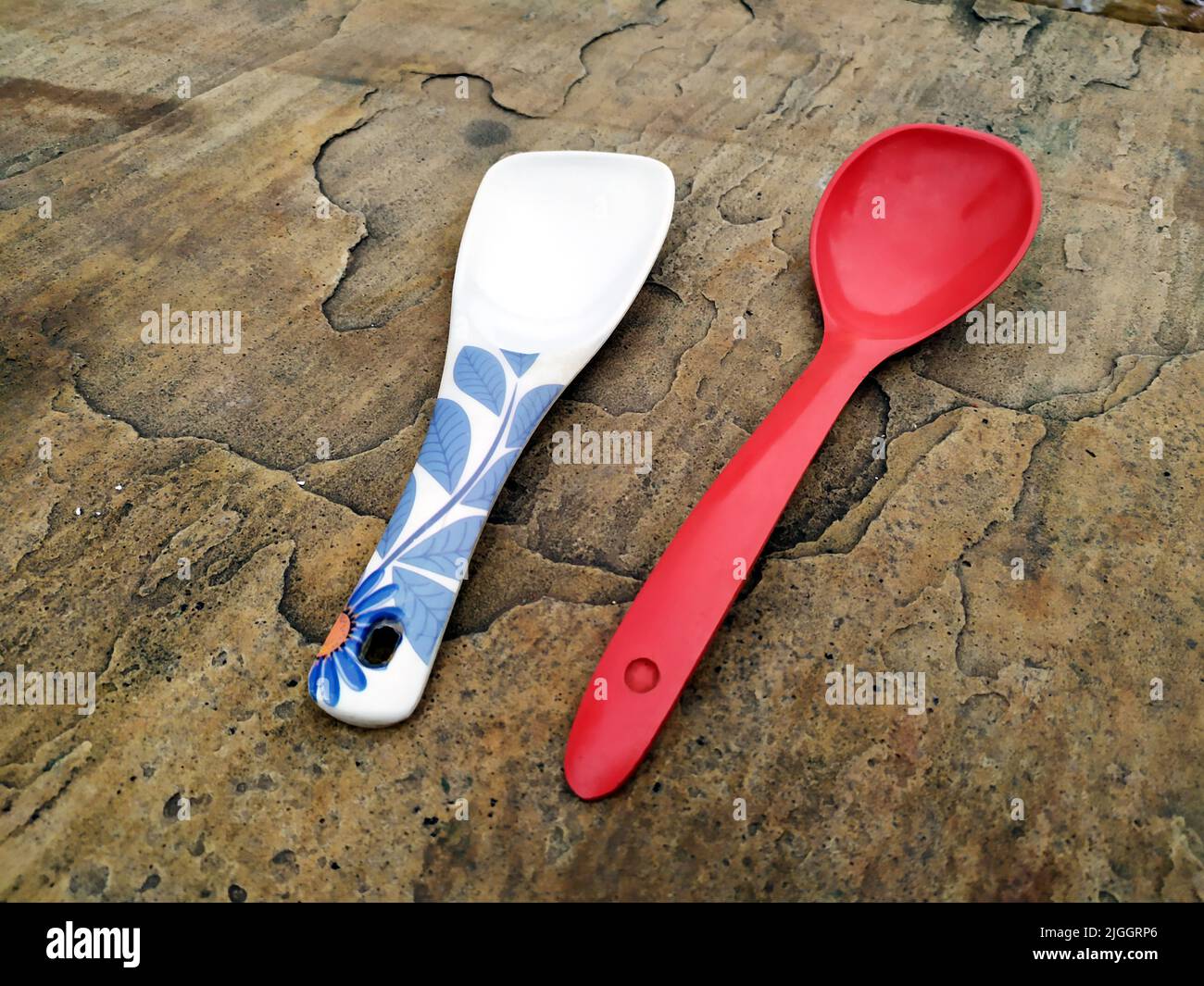 white and red big spoon on the stone background Stock Photo - Alamy