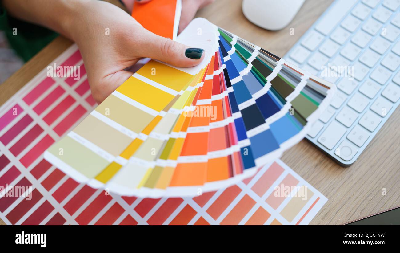 Interior designer holding fan of colourful samples in hand Stock Photo ...