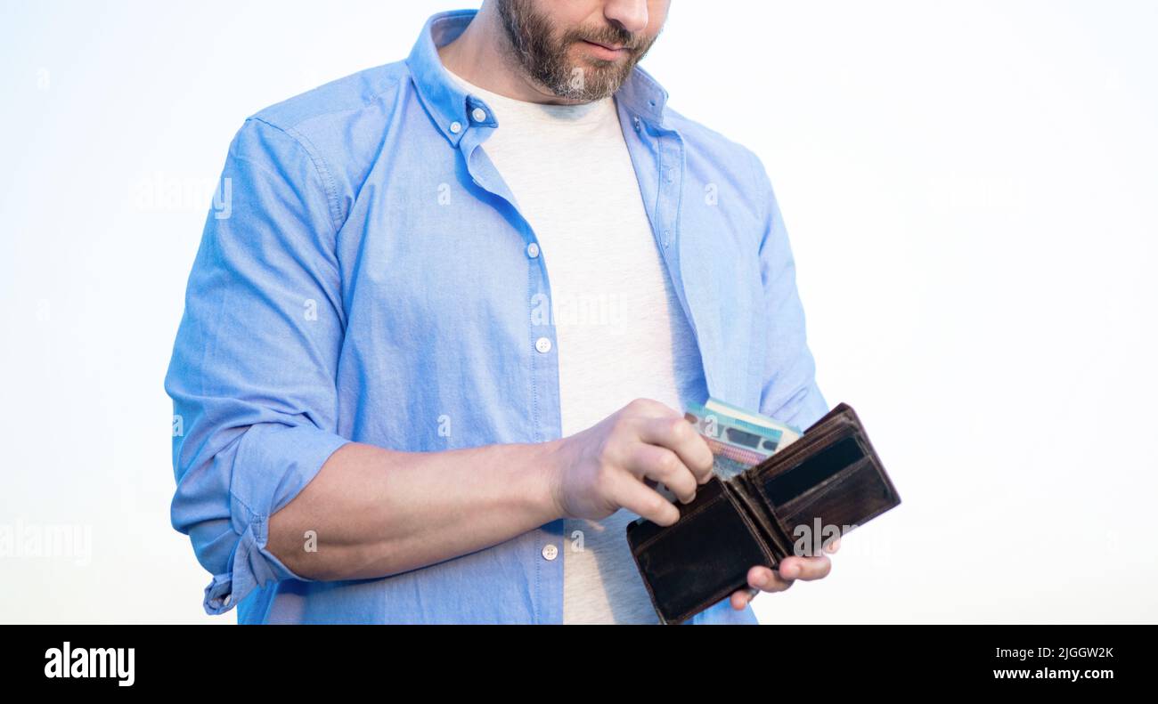 Serious man crop view taking cash money out of wallet sky background ...