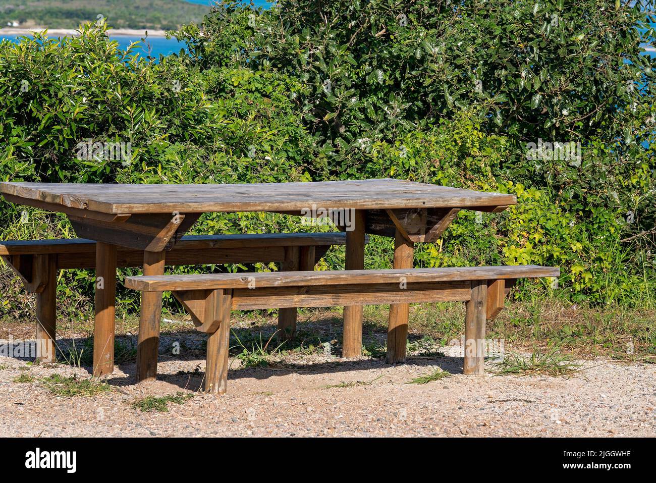 A plain wooden picnic table and seating for tourists to use at ocean ...