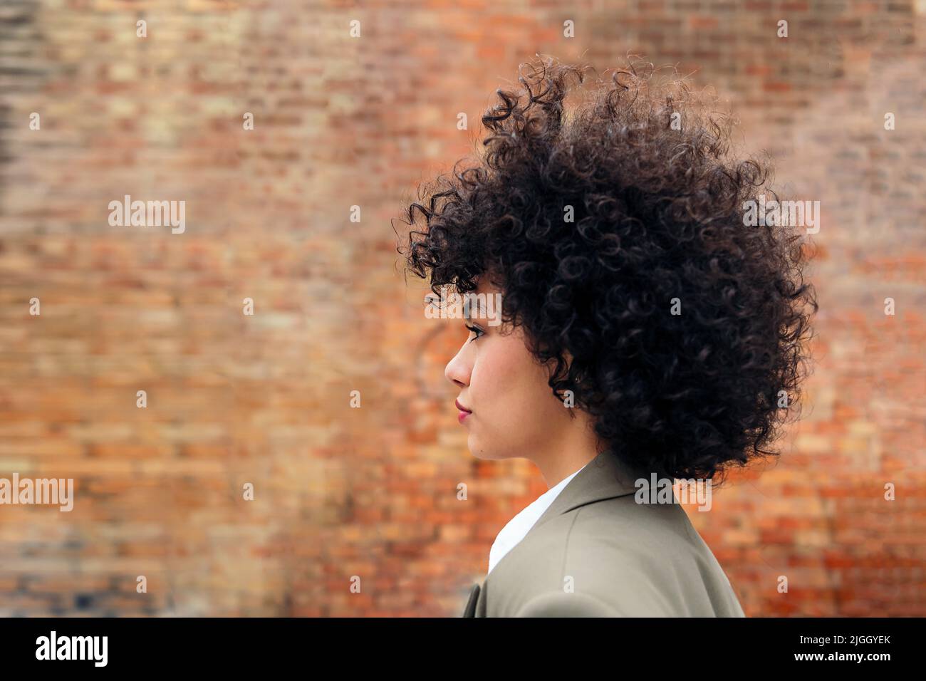 profile portrait of a young woman with curly hair Stock Photo - Alamy