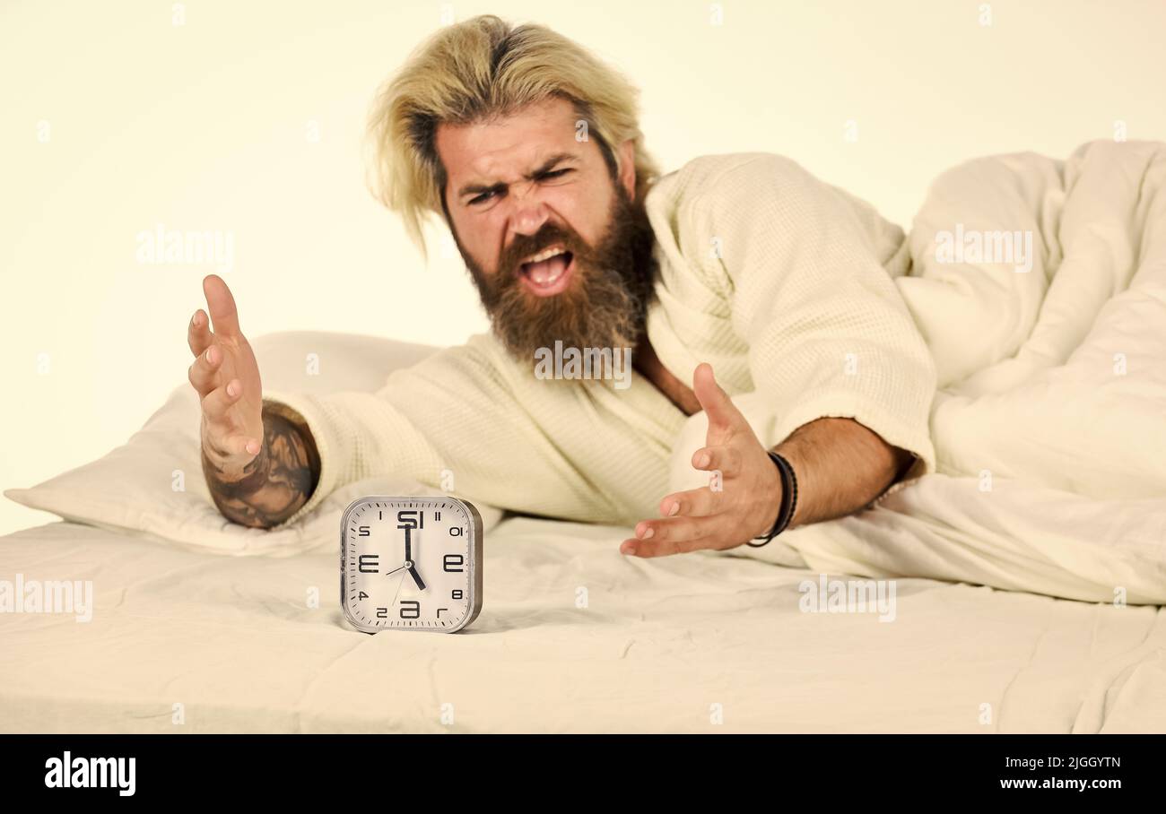 Destroy the Clock. handsome angry man lies in bed indoors wake up turn ...