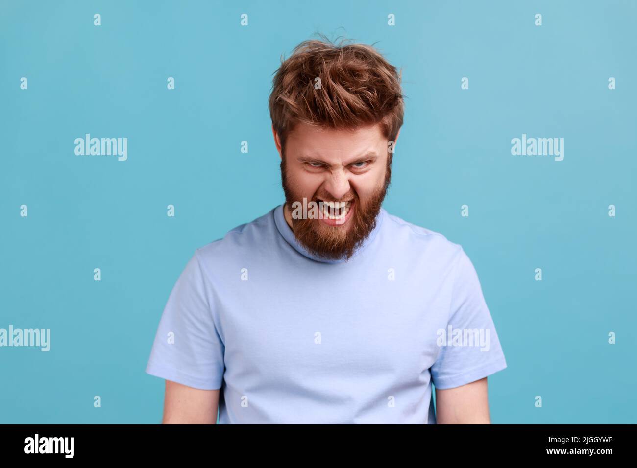 Portrait of bearded angry furious mad man standing and screaming with ...