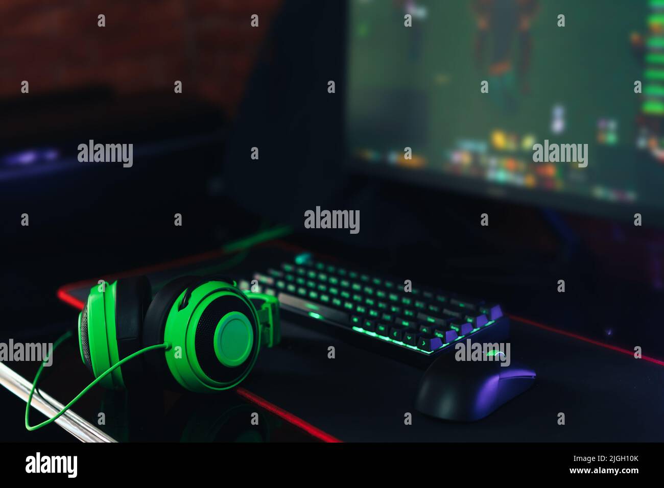 Gaming accessories with green backlight in front of the monitor Stock ...