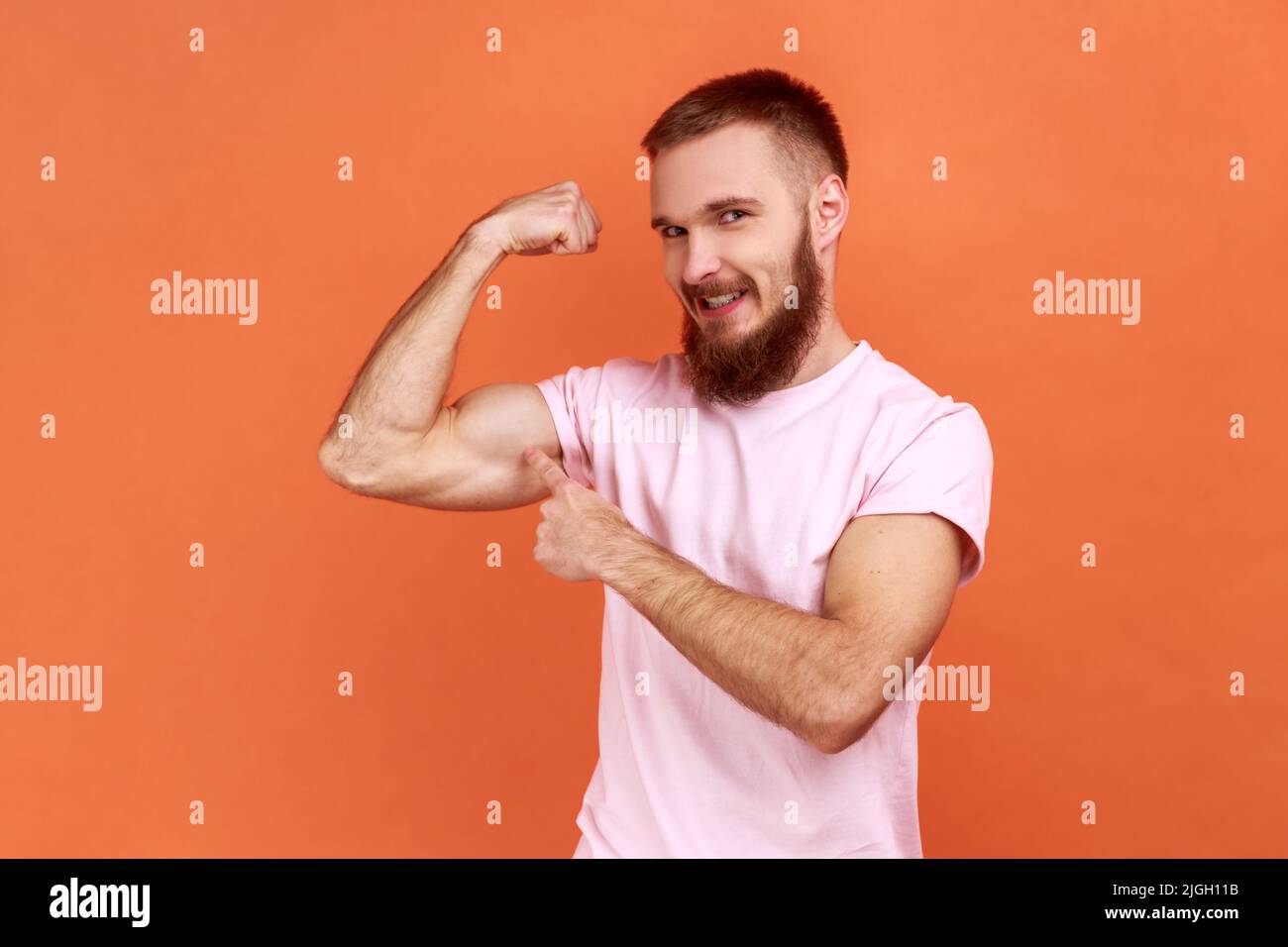 Portrait of proud strong bearded man pointing at raised hand ...