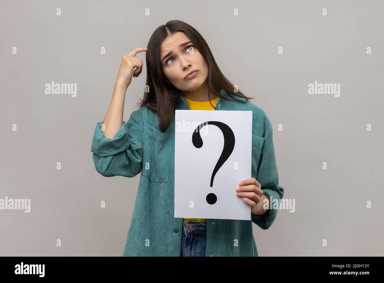 Portrait of pensive thoughtful woman looking away, holding paper with ...