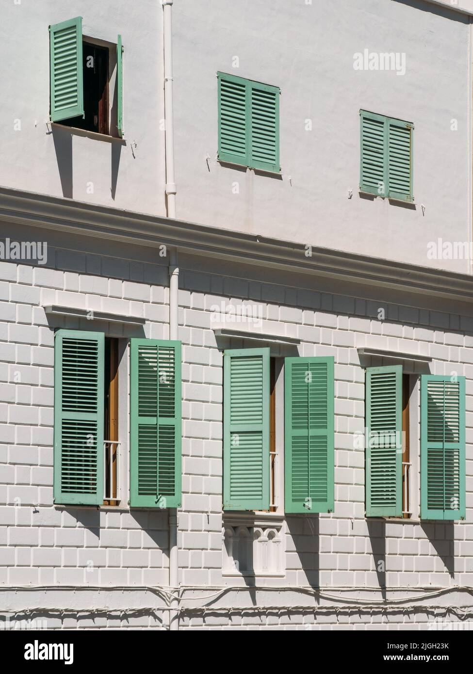 Wooden light green shutters and windows of a typical white house on the ...