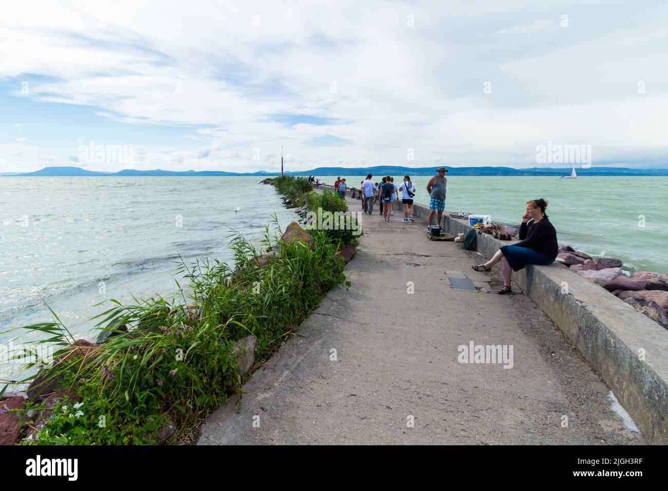 Tourists walking on pier at Lake Balaton southern coast, Balatonlelle ...