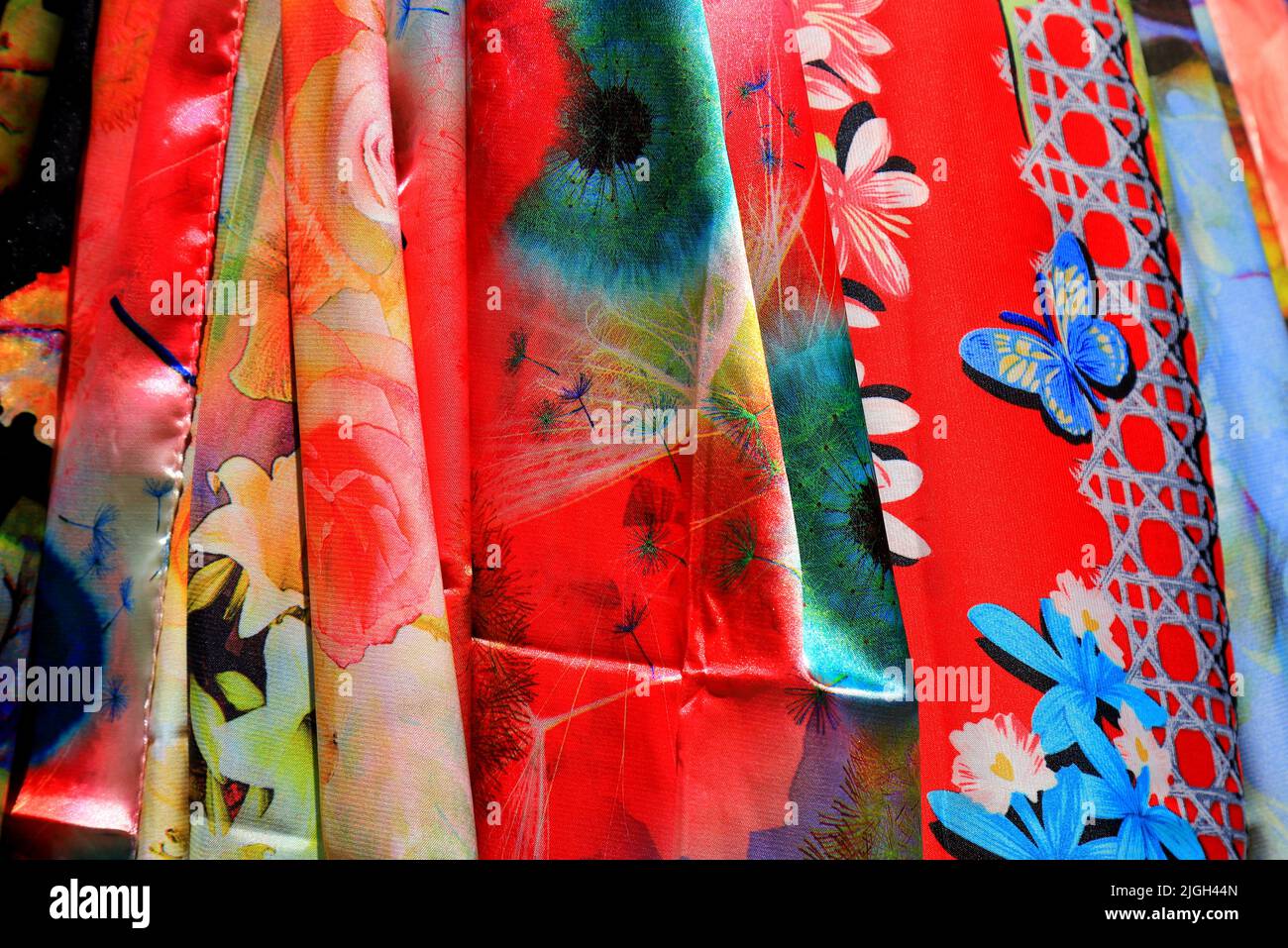 Colorful shawls, scarves on display in shop, background fabric texture ...