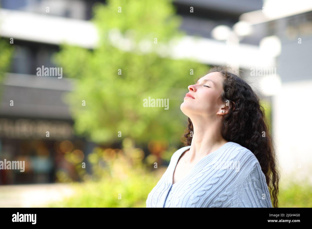 Profile of a woman relaxing breathing fresh air in the street Stock ...