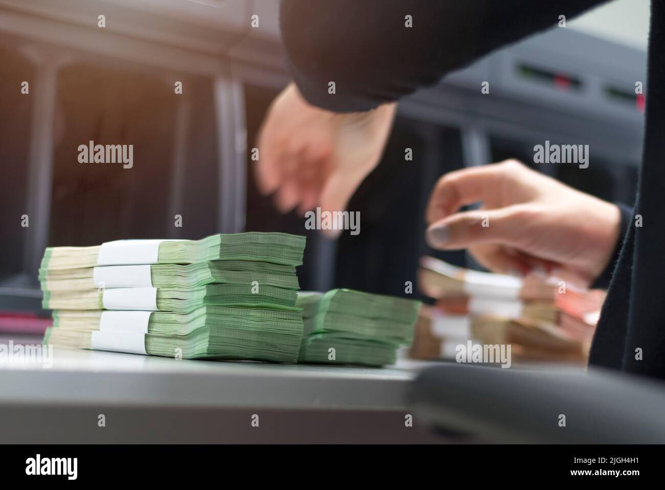 Large amounts of money in the bank. Bank employees sorting and counting ...