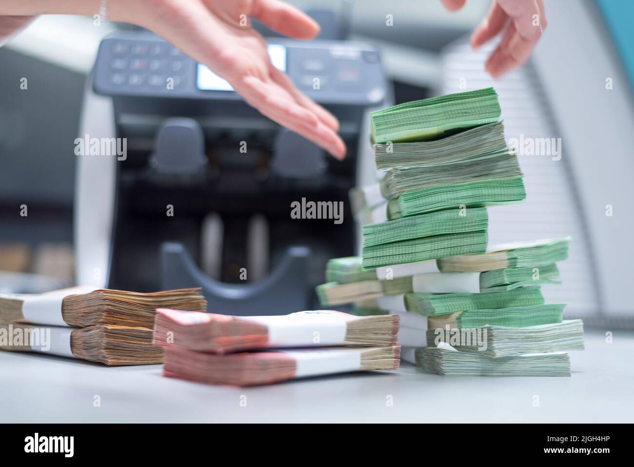 Large amounts of money in the bank. Bank employees sorting and counting ...