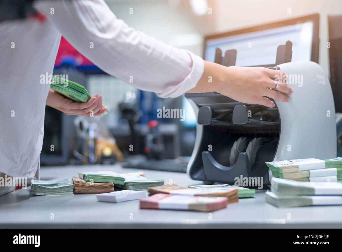 Large amounts of money in the bank. Bank employees sorting and counting ...