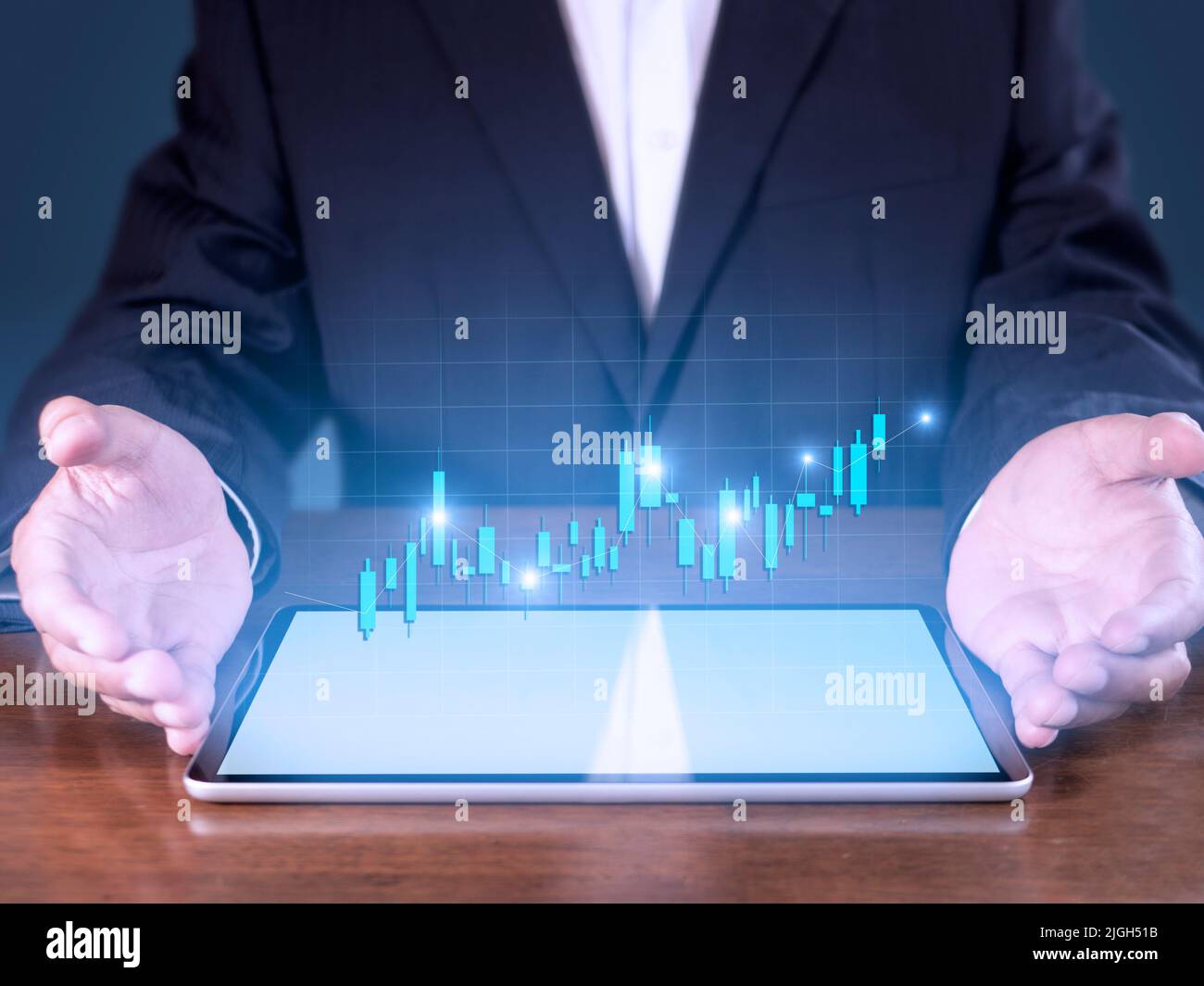 Hand of businessman present tablet analysis stock market graph growth ...