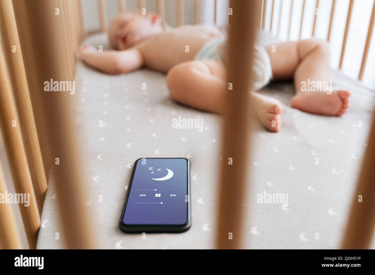 Selective focus of little boy in crib falling asleep with the help of ...