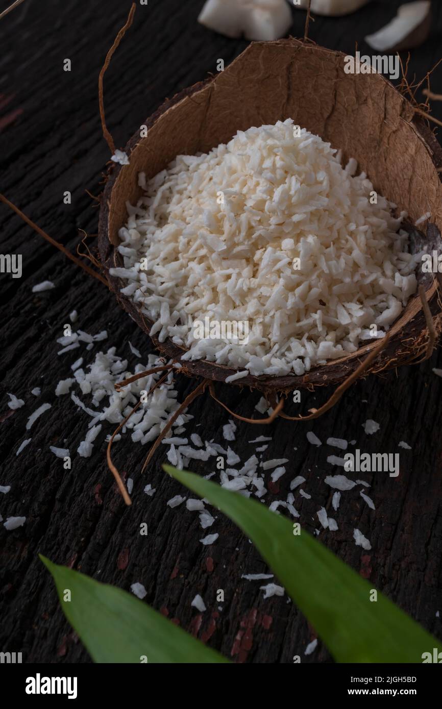Chopped coconut on a wooden background, top view. Coconut milk and ...