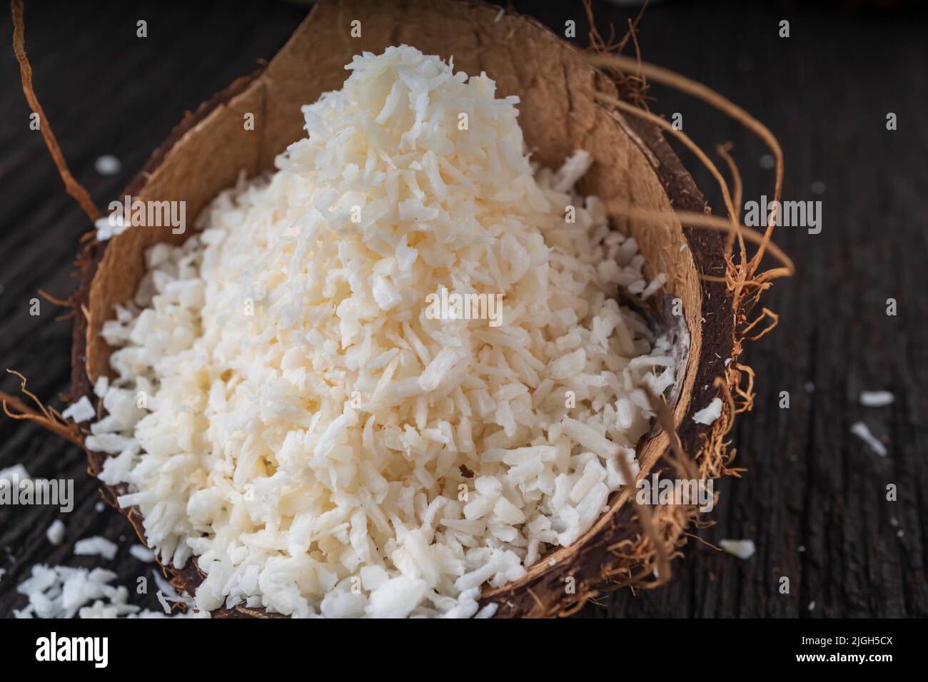 Chopped coconut on a wooden background, top view. Coconut milk and ...