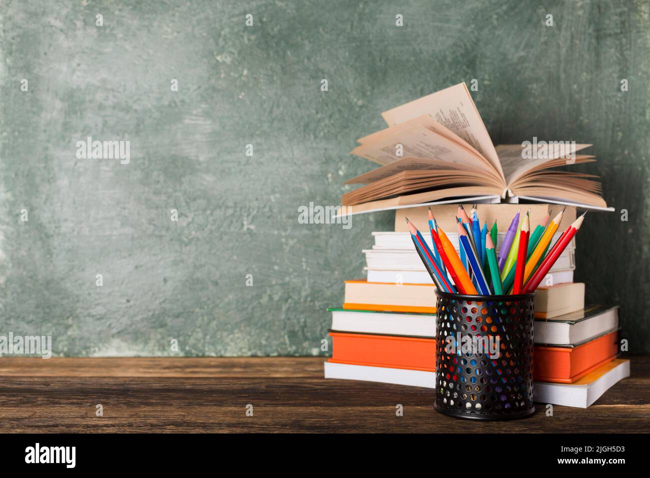 Stack of books and stationery on the background of the school board ...