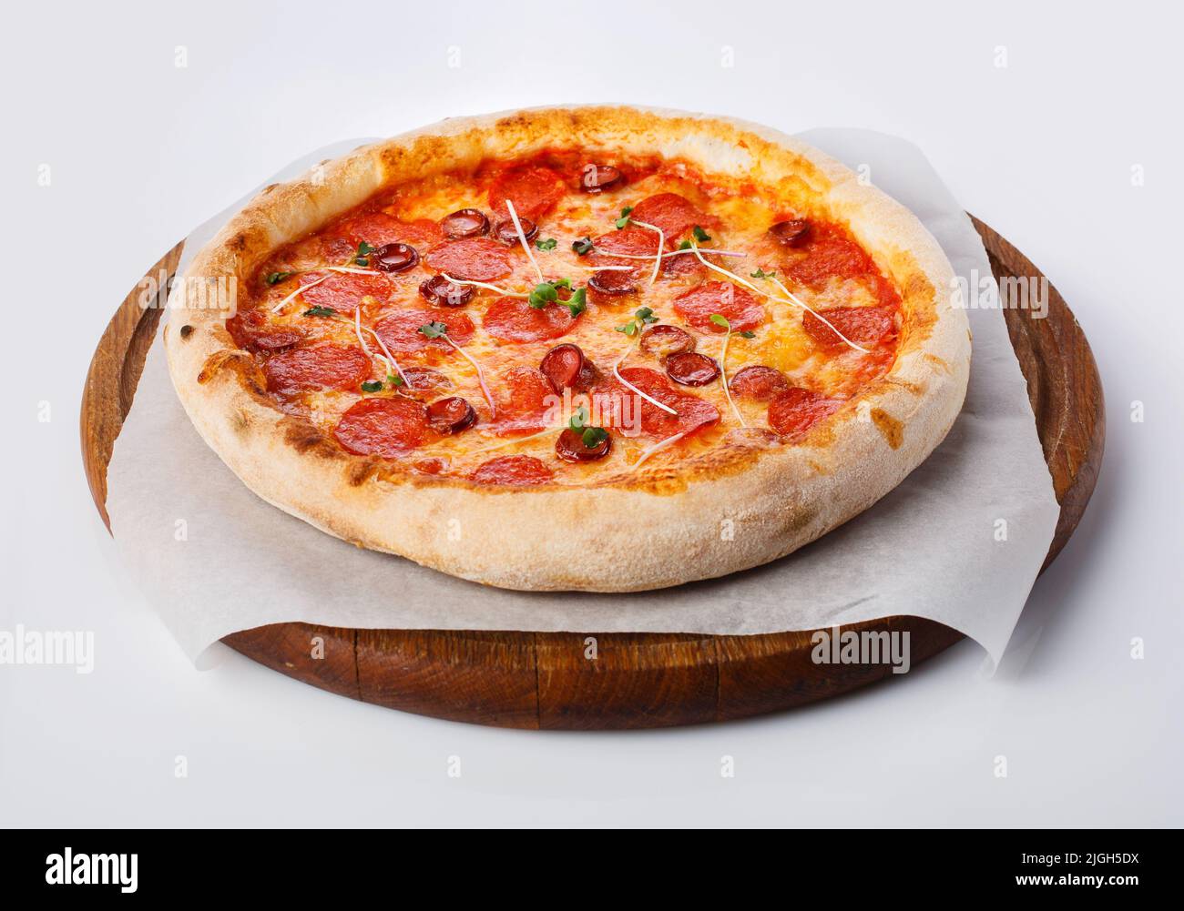 Top view of hot pizza on a wooden stand. Pepperoni pizza. Tomato base ...