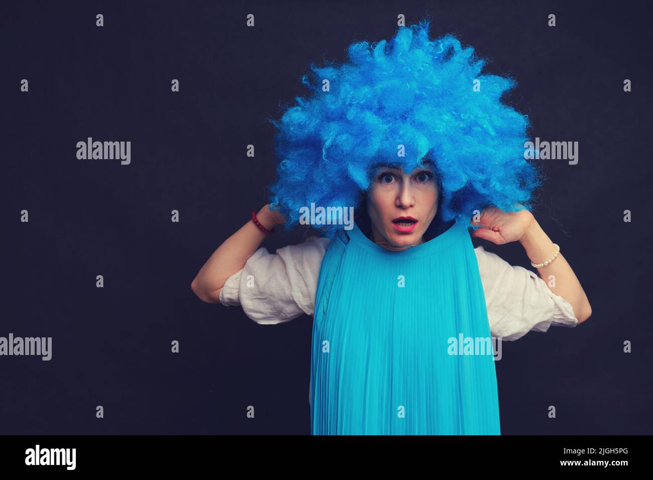 Woman in funny wigs give performance on a studio black background ...