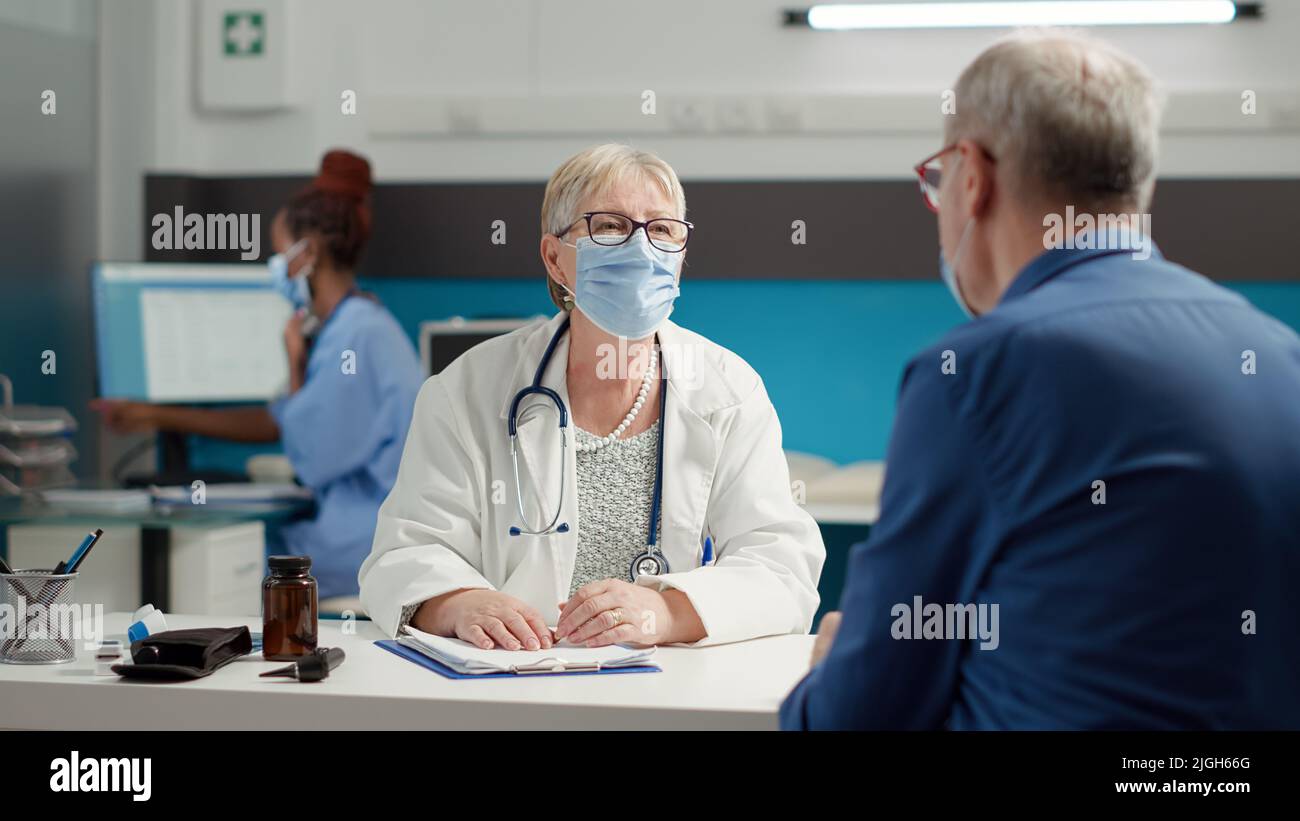 Female medic consulting retired sick patient in medical cabinet ...