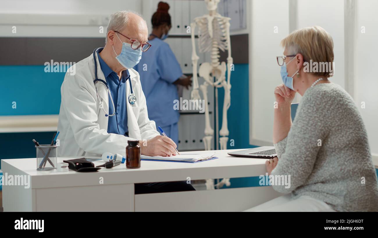 General practitioner taking notes on medical checkup papers, doing ...