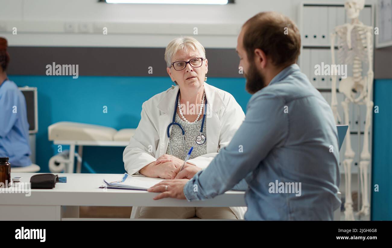 Male patient signing checkup appointment report on papers to receive ...