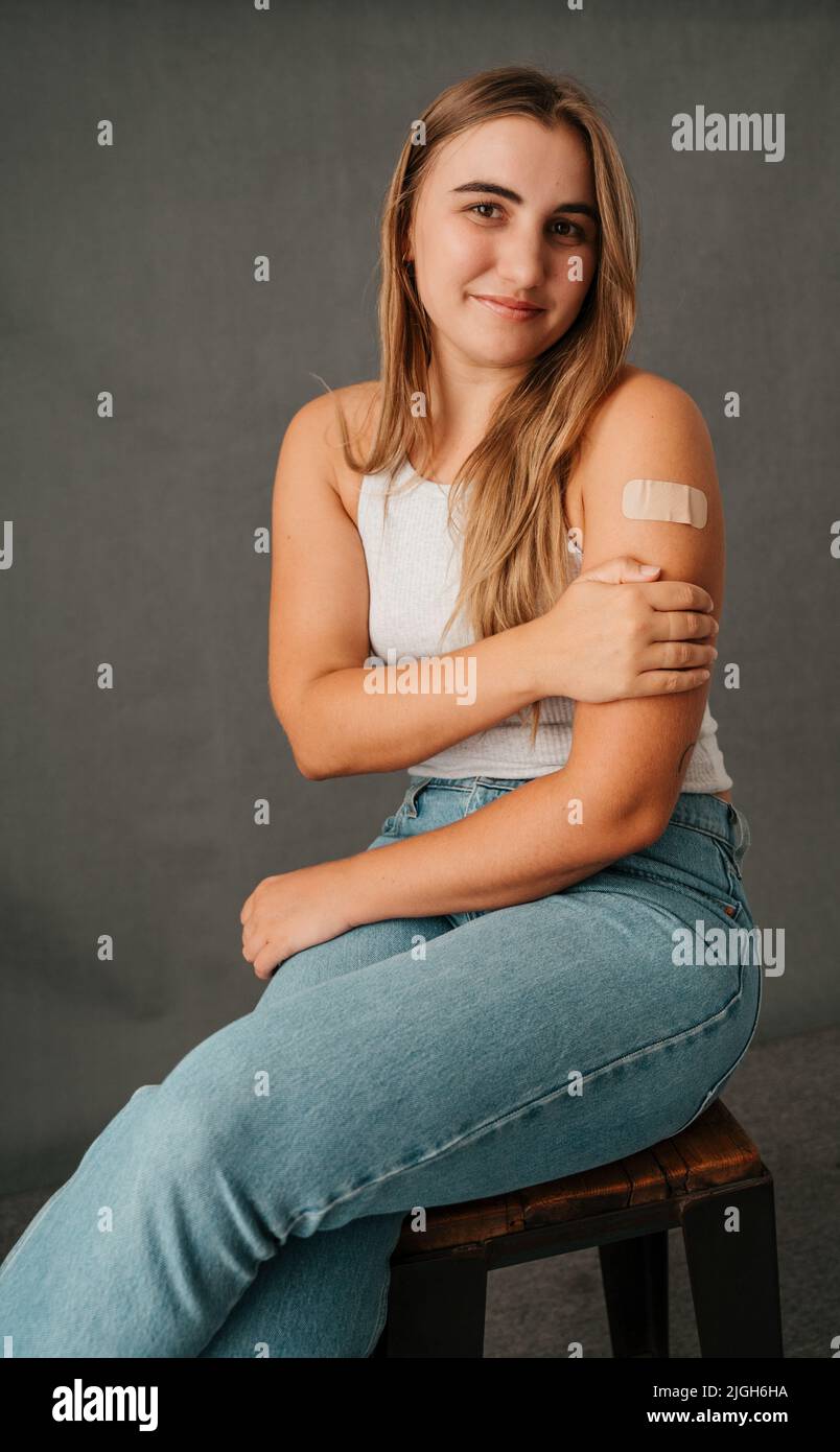 Close up Caucasian female holding her injured arm sitting on a chair ...